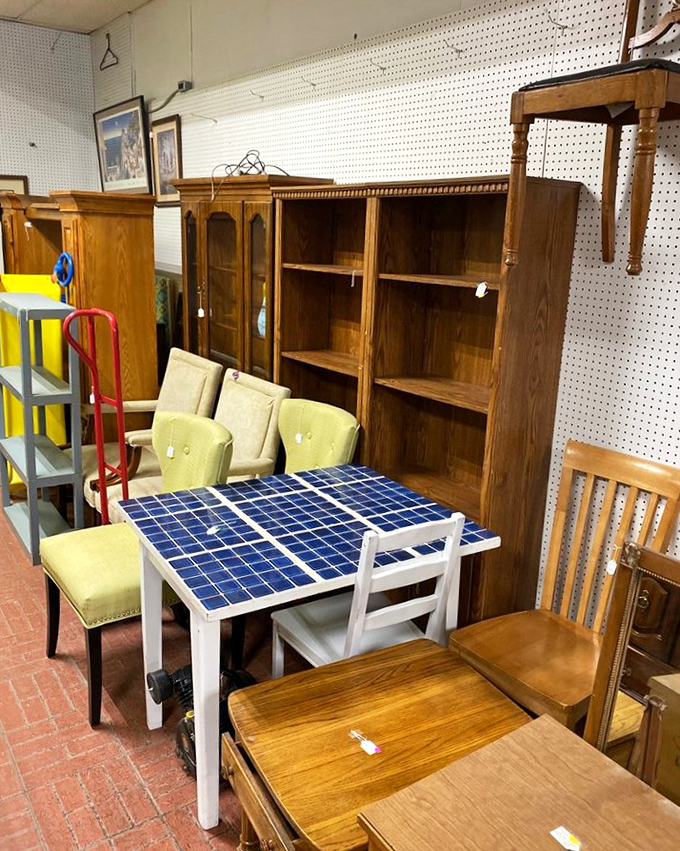 Mid-century meets modern in this furniture tableau, where a blue-tiled table pops against warm wooden shelving units waiting for their second act.
