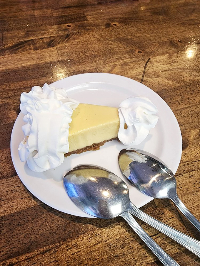 Key lime pie that strikes the perfect balance between sweet and tart. Those two spoons? Pure optimism—nobody's sharing this slice of heaven.