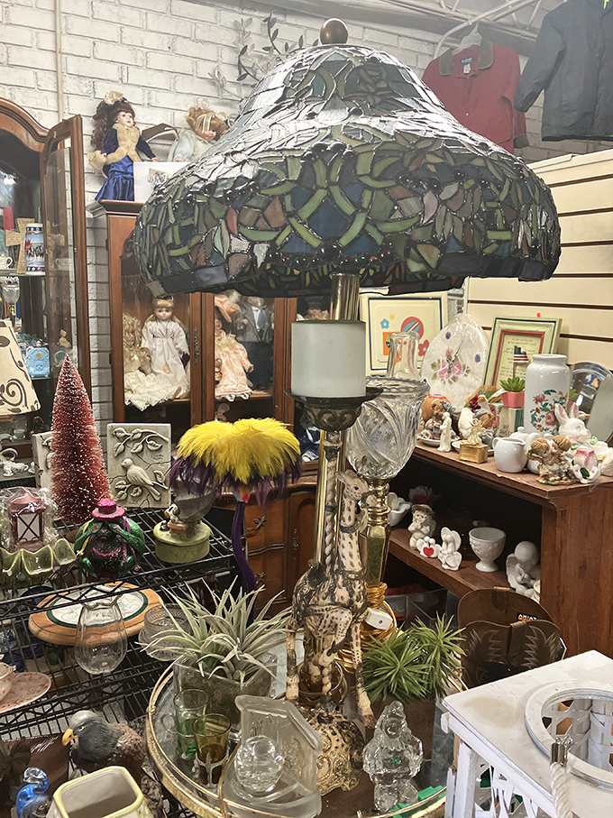 Not your average lighting department &ndash; this stained glass Tiffany-style lamp towers over porcelain figurines and vintage glassware in perfect antique harmony.