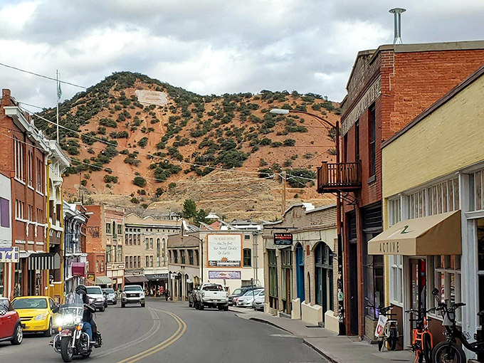The curved streets of Bisbee follow the natural contours of the canyon, with colorful buildings nestled against the backdrop of desert mountains. 