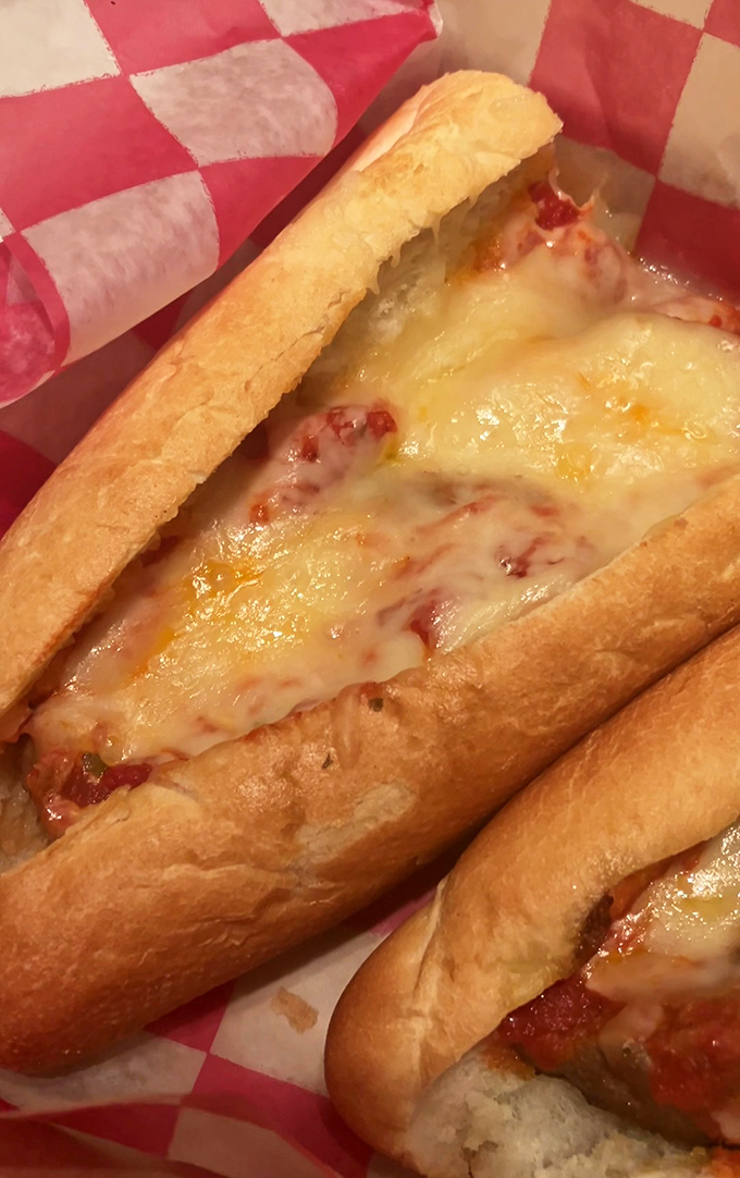 Not just a sandwich but an engineering marvel of melted cheese and sauce. The checkered paper is less food wrapper and more victory flag.