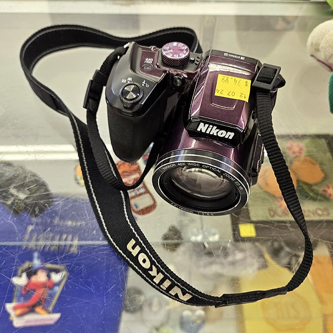 This purple Nikon camera has captured someone's memories and now waits patiently to document your adventures for a fraction of retail price.