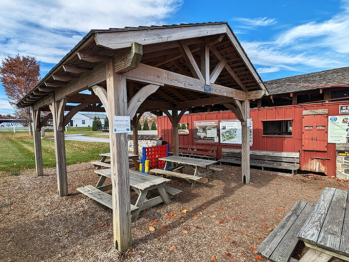 The waiting area where modern life pauses&mdash;rustic picnic tables under a hand-hewn shelter invite visitors to slow down before their journey.