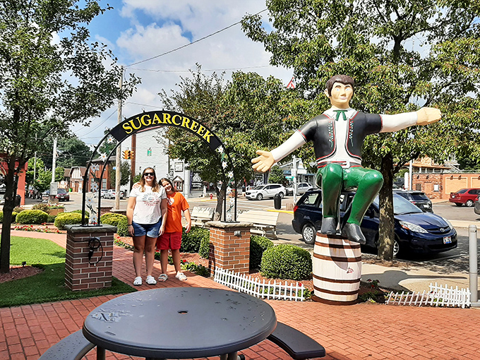 The Sugarcreek welcome arch frames the town's Swiss mascot, creating the perfect entrance to a slice of Europe that somehow landed in Ohio.