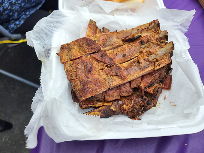 Pork ribs stacked like meaty dominoes, their bark telling stories of patient smoking and generations of know-how.