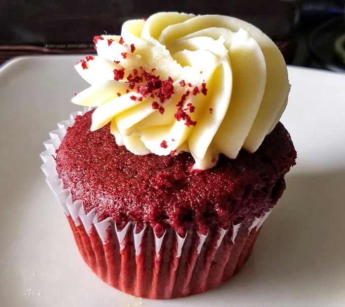 Red velvet cupcake perfection: the color of Dorothy's slippers, the texture of a cloud, and enough cream cheese frosting to make you forget your name.