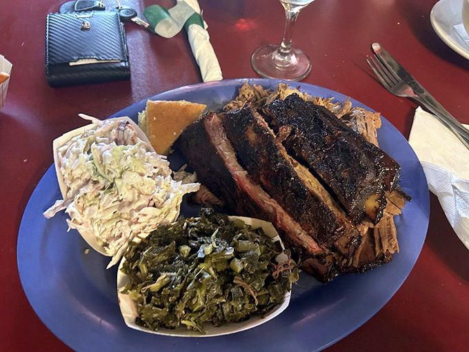 Ribs with that telltale smoke ring and perfect bark, flanked by collard greens and coleslaw. The holy trinity of Southern barbecue.