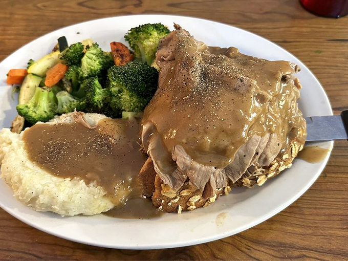 Comfort on a plate – tender roast beef swimming in gravy that's clearly been simmering since yesterday, alongside vegetables pretending to make it healthy.