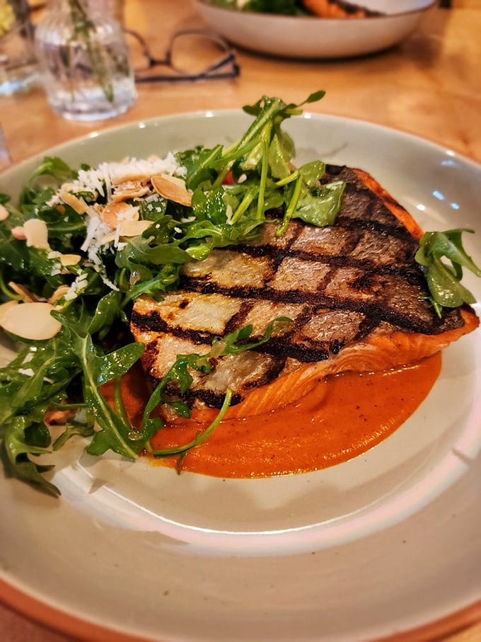 Salmon with grill marks so perfect they could be framed. The vibrant sauce beneath is like a sunset on a plate.