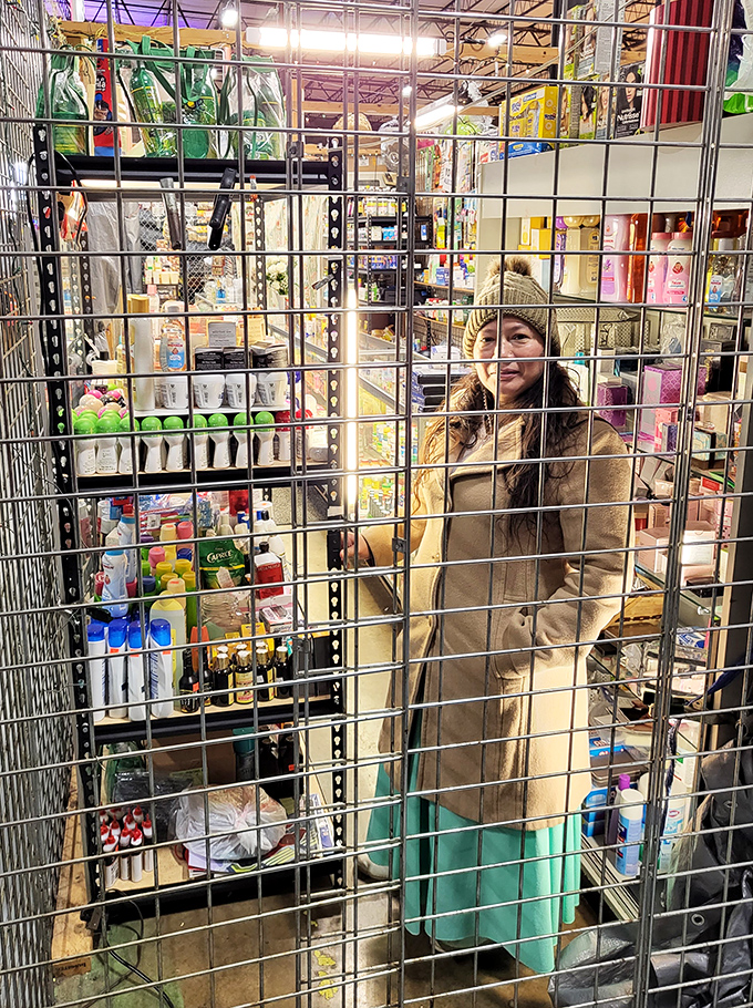 A vendor stands ready behind her display of merchandise, surrounded by the fruits of her entrepreneurial spirit.