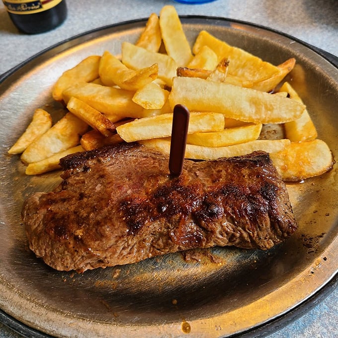 This steak doesn't need a fancy silver dome reveal. Its sizzling simplicity on a metal plate says everything about the restaurant's priorities.