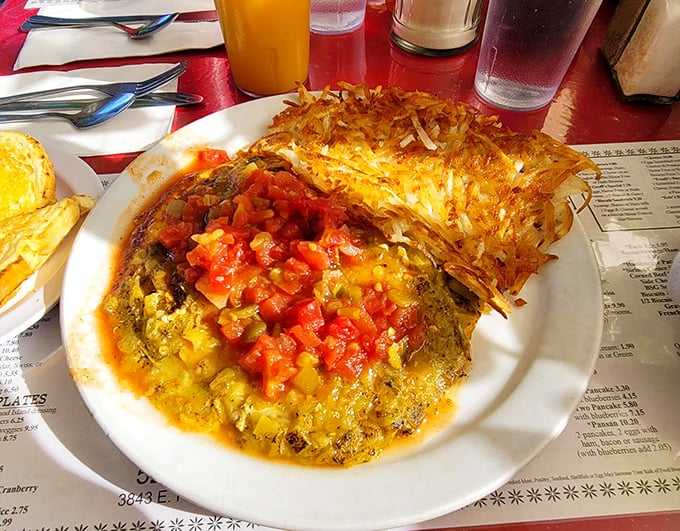 This isn't just an omelet&mdash;it's an architectural marvel of eggs, melted cheese, and fresh salsa. The crispy hash browns standing guard are non-negotiable.
