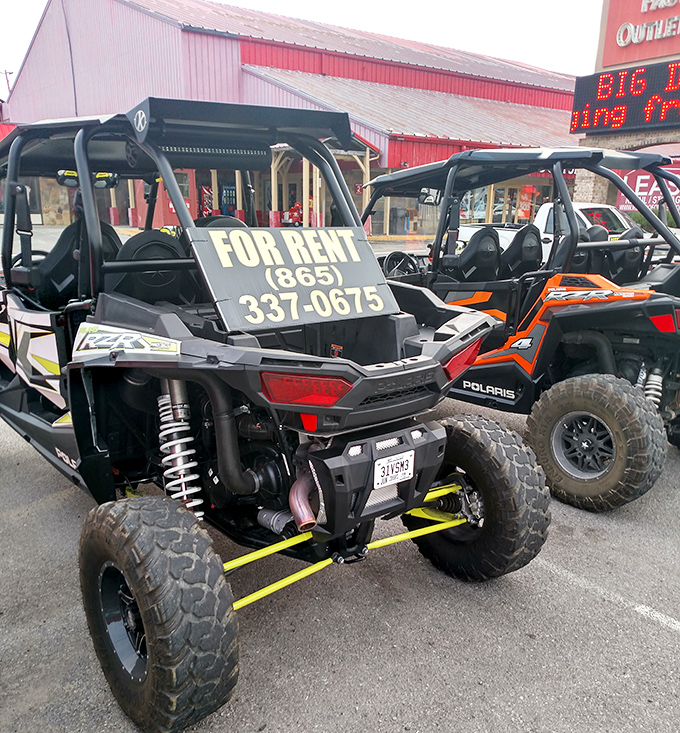 These mountain-ready UTVs sit patiently in the parking lot, silently judging your decision to buy another t-shirt instead of embracing adventure.