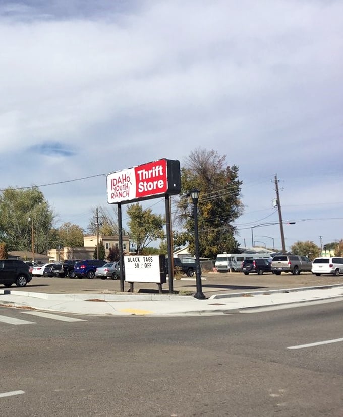 The roadside beacon that calls to bargain hunters like a siren song, complete with the promise of "BLACK TAGS 50% OFF."