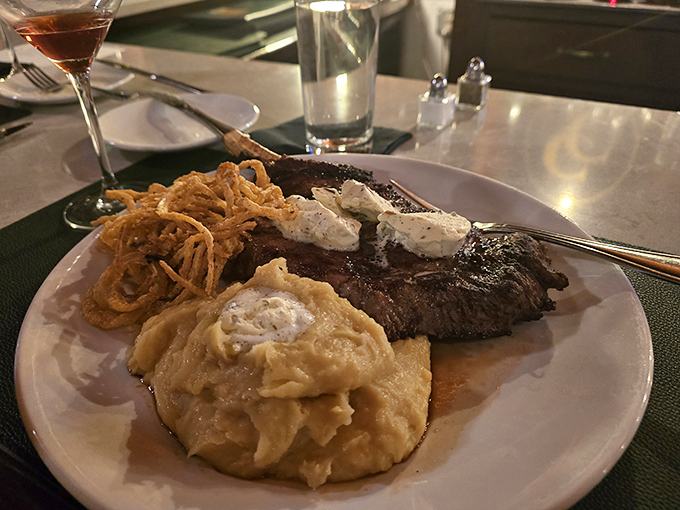 This steak arrives with compound butter slowly melting into its perfectly seared surface, alongside mashed potatoes that could make a grown adult weep with joy.