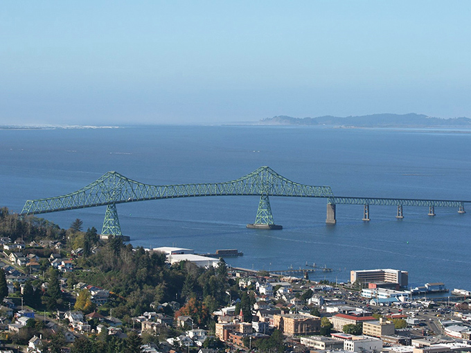 Engineering meets artistry in this emerald span. The Astoria-Megler Bridge stretches across the Columbia River like a green necklace against blue waters.
