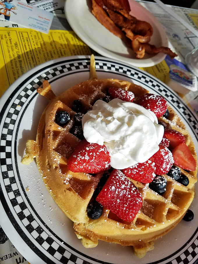 A waffle that's dressed for success with fresh berries and whipped cream. The checkered plate is just letting you know you've crossed the finish line of breakfast excellence.