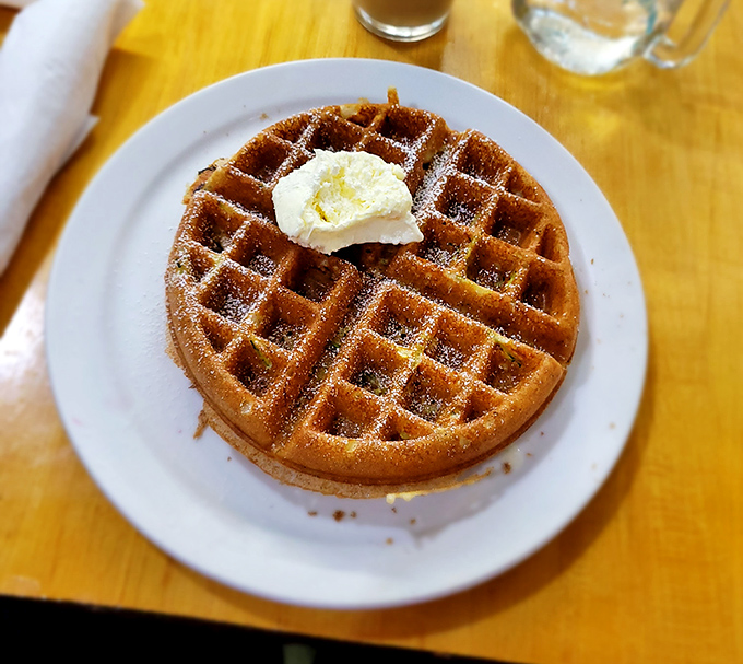 Waffle perfection is simple: golden-brown squares, a dollop of butter, and a dusting of powdered sugar. Sometimes the classics need no improvement.