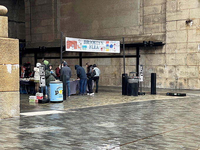 Under the archway, Brooklyn Flea welcomes shoppers into a covered space where vintage treasures wait in organized, curated glory.