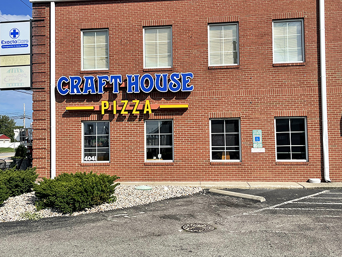 Craft House Pizza's bold blue sign stands out against the brick like a beacon for those seeking pizza perfection.