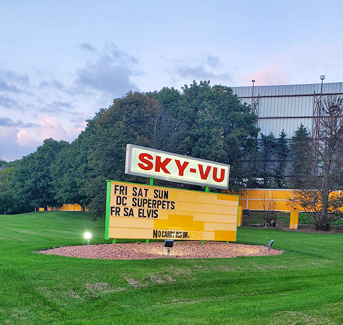 "Elvis has entered the drive-in!" Sky-Vu's cheerful yellow marquee pops against emerald Wisconsin greenery, promising superhero pets and the King himself.