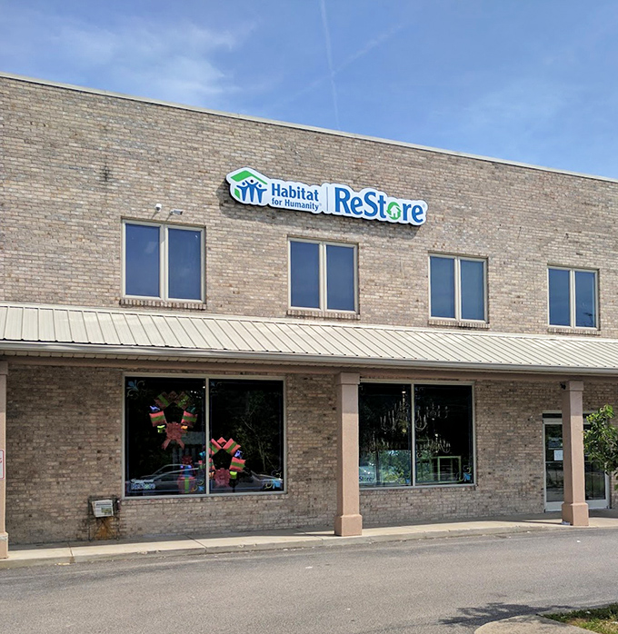 The Habitat ReStore sign proudly announces its mission above a building full of home improvement treasures. DIY paradise awaits inside!