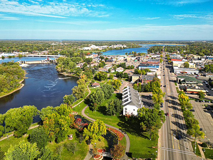 An aerial view of Little Falls captures its blend of scenic riverfront and historic downtown charm under a bright blue sky.