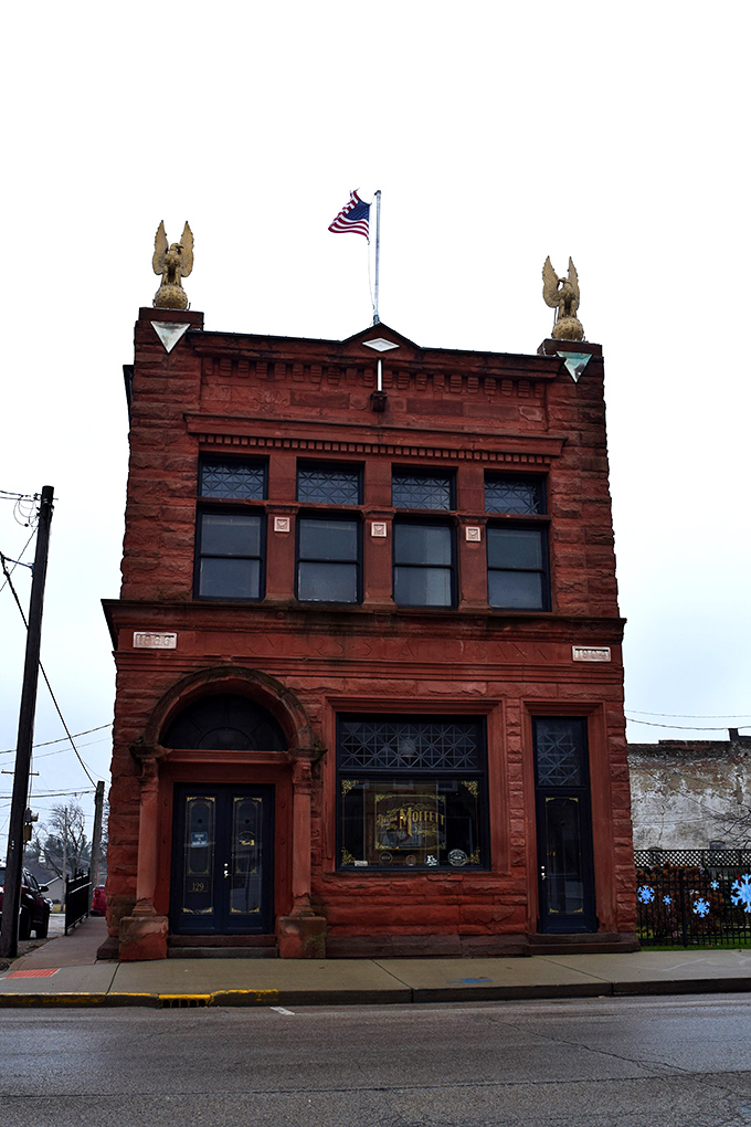 This striking red sandstone building in Mason proudly displays American charm with its flag flying high above timeless architectural details.