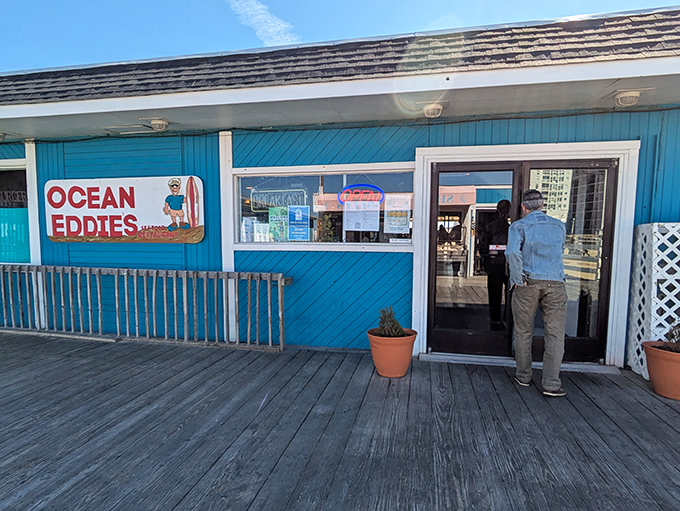 Ocean Eddie's blue boardwalk presence stands out like that one friend who always knows where to find the best seafood.