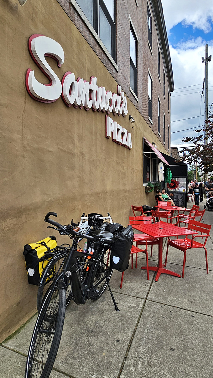 Red chairs pop against weathered brick like exclamation points celebrating South Philly's pizza heritage beautifully.
