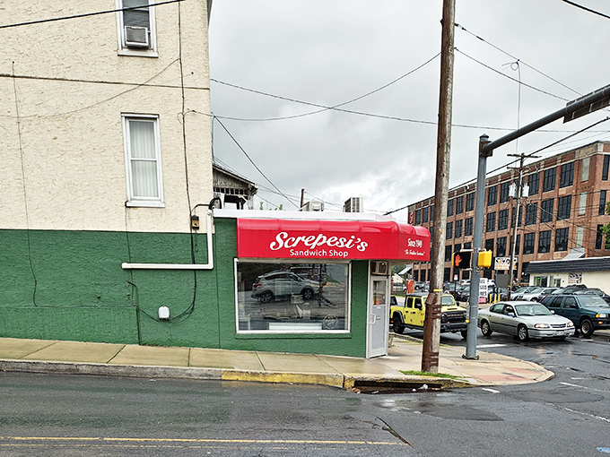 Red awnings and brick walls create the perfect backdrop for serious sandwich artistry that never disappoints locals.