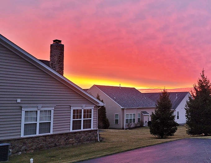 Mother Nature's nightly masterpiece—a blazing sunset paints the sky in cotton candy pinks and molten gold behind The Villages at Hillview's cozy homes.