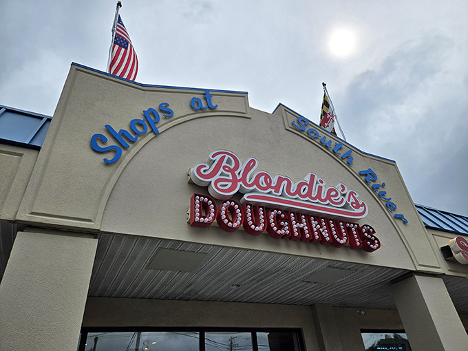 With American flags flying and "Shops at South River" signage, Blondie's Doughnuts embodies small-town Maryland charm and big-time flavor.