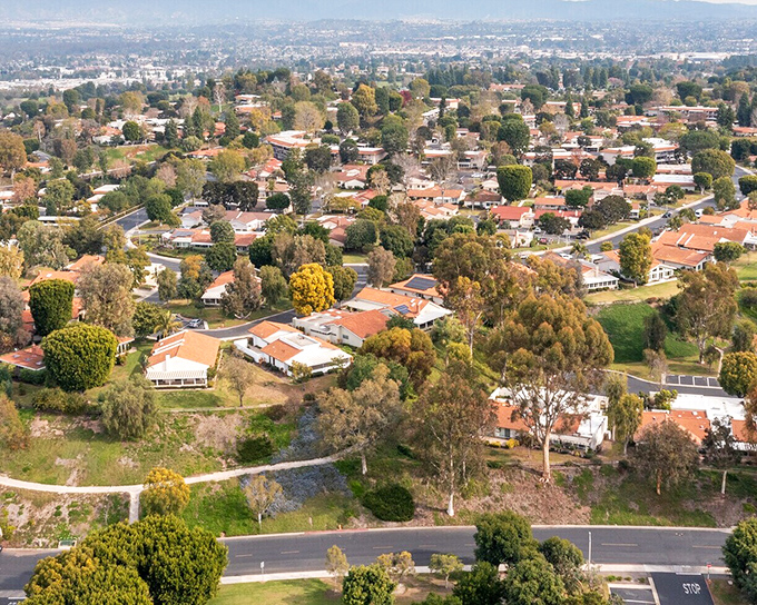 Laguna Woods is a peaceful, tree-filled community where winding streets and warm-toned homes create a calm suburban charm.