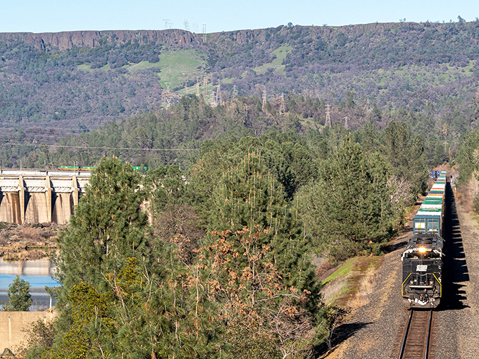 Iron horse meets concrete giant! Oroville's rugged landscape showcases California's industrial ballet &ndash; no expensive theater ticket required.