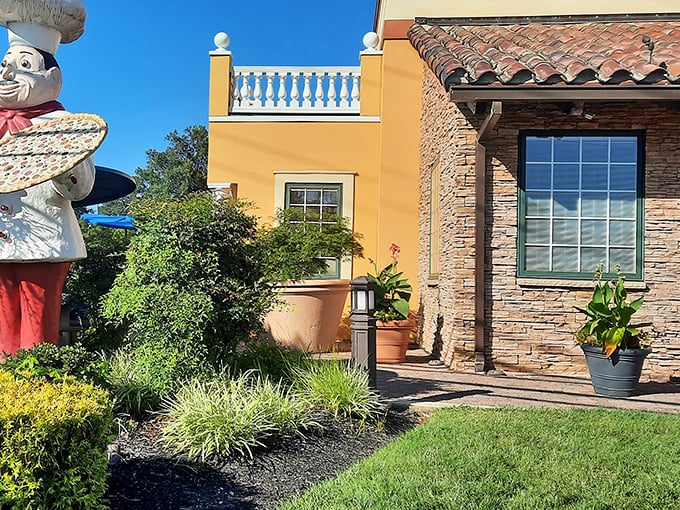 The chef statue stands guard outside Pizza John's, promising Italian treasures within these yellow walls.