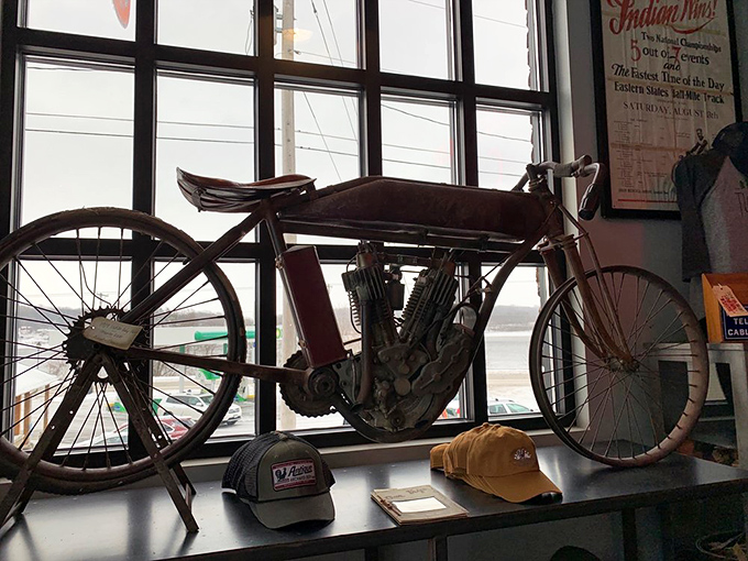 The 1909 Indian Baby Twin motorcycle sits regally against the window, silently telling tales of dusty roads and the dawn of American motorcycle culture.