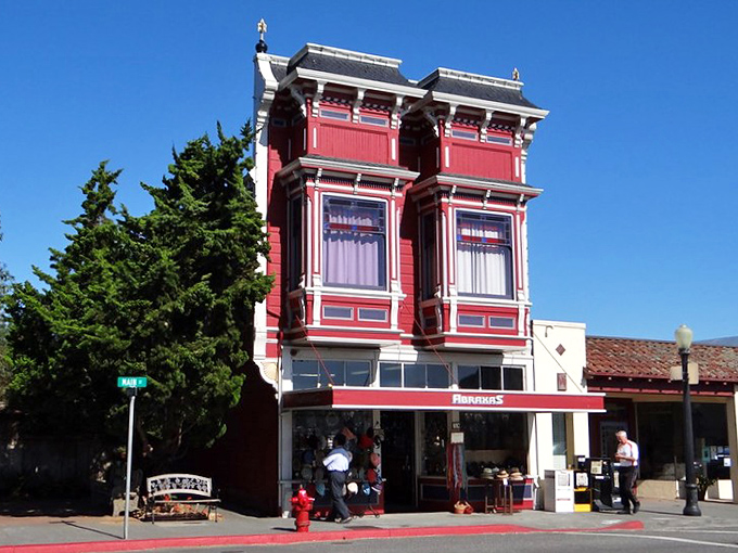 This crimson Victorian storefront pops against the blue sky like a perfectly composed painting, proving that shopping can indeed be architectural theater.