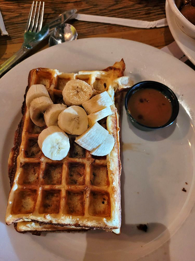 Golden waffle perfection topped with fresh bananas and maple syrup. The crispy edges and fluffy interior create the texture contrast of champions.
