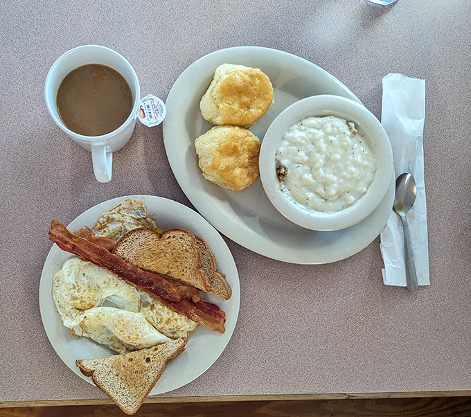 Morning glory on a plate: fluffy biscuits, creamy grits, and eggs that remind you why breakfast might actually be the most important meal.