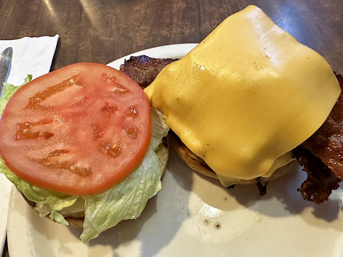 Behold the cheeseburger in its natural habitat – unpretentious, perfectly melted cheese, fresh toppings, and absolutely zero need for a fancy aioli or artisanal bun.