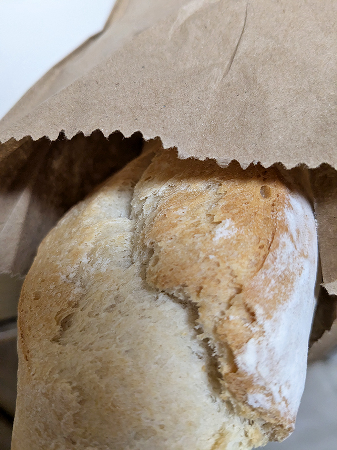 Crusty baguette wrapped like a precious gift, because sometimes the simplest bread deserves the most thoughtful packaging treatment.