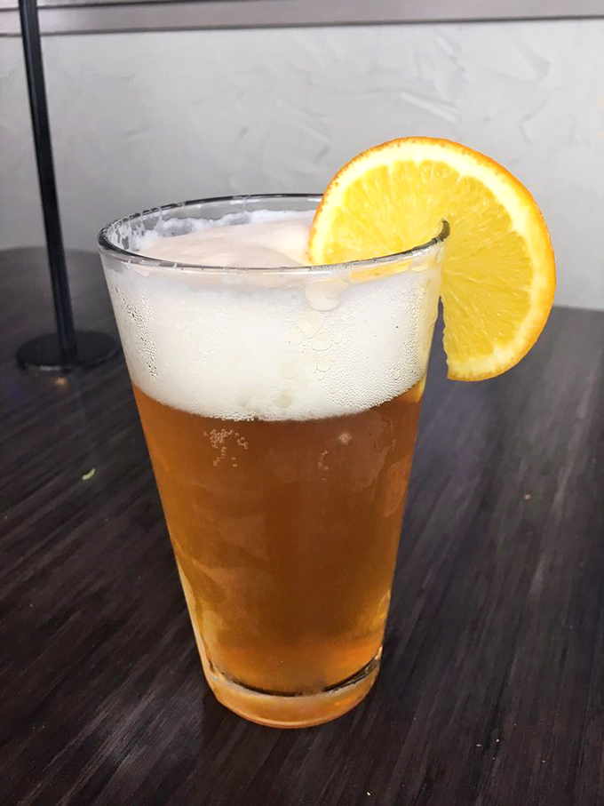A perfectly poured beer with a citrus accent—because sometimes you need something bright to cut through all that beautiful burger richness.