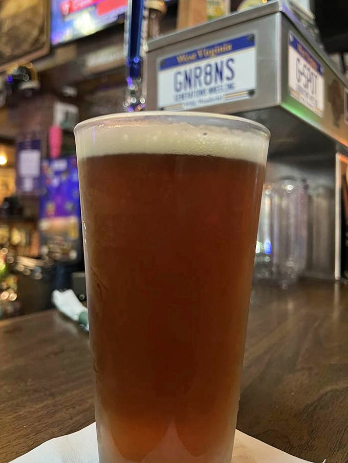 A perfectly poured beer with just the right amount of head, waiting patiently beneath a West Virginia license plate.