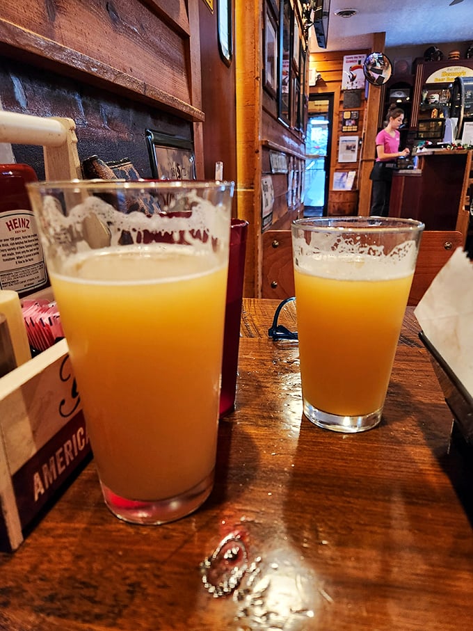 Two golden beers catching the light like liquid sunshine—the perfect companions for tackling any burger challenge that awaits.