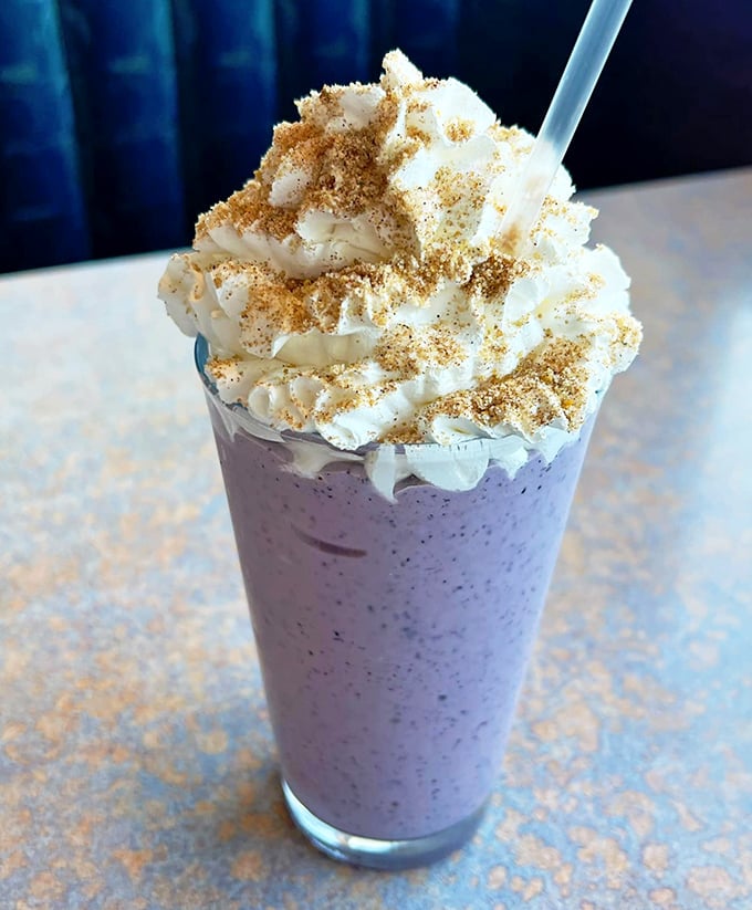 A milkshake that looks like it graduated from dessert college with honors. That whipped cream crown deserves its own royal title.