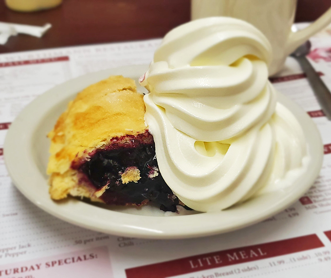 Berry pie that strikes the perfect balance between sweet and tart, topped with a swirl of whipped cream that's practically architectural in its perfection.