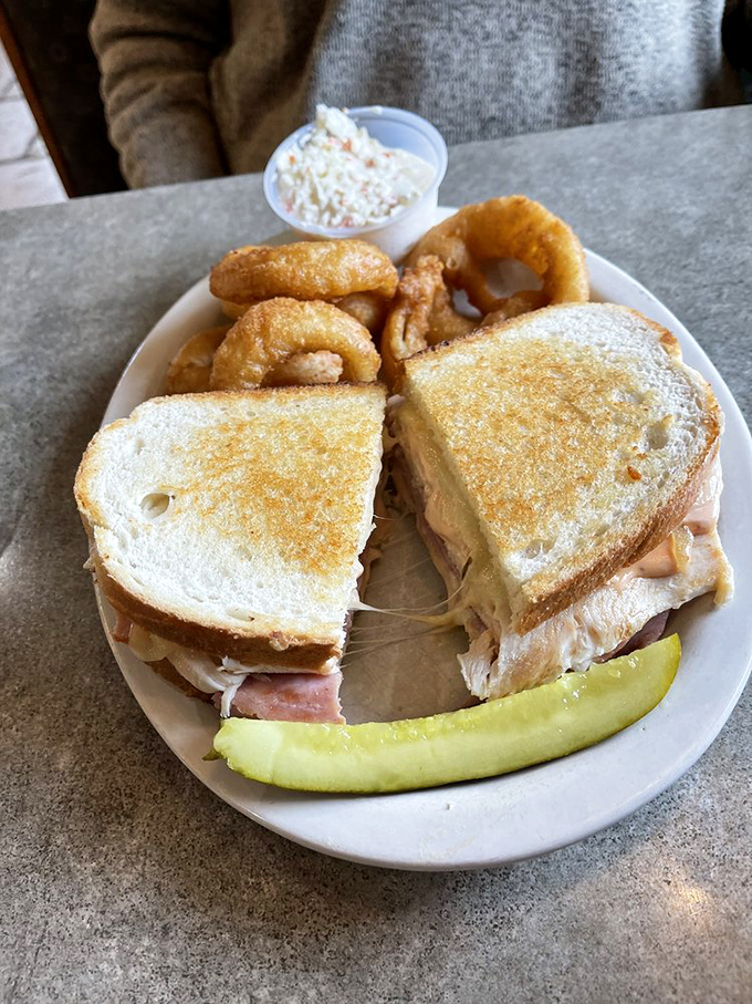 This sandwich isn't just lunch &ndash; it's architectural genius stacked between bread with onion rings playing the supporting role they were born for.