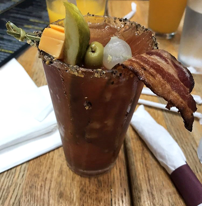 The Bloody Mary comes armed with bacon and garnishes, essentially serving as both cocktail and appetizer in one strategic glass.