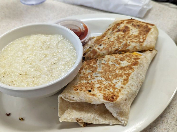 This breakfast burrito isn't just wrapped—it's tucked in like a food baby next to a bowl of grits that's creamier than your favorite love song.